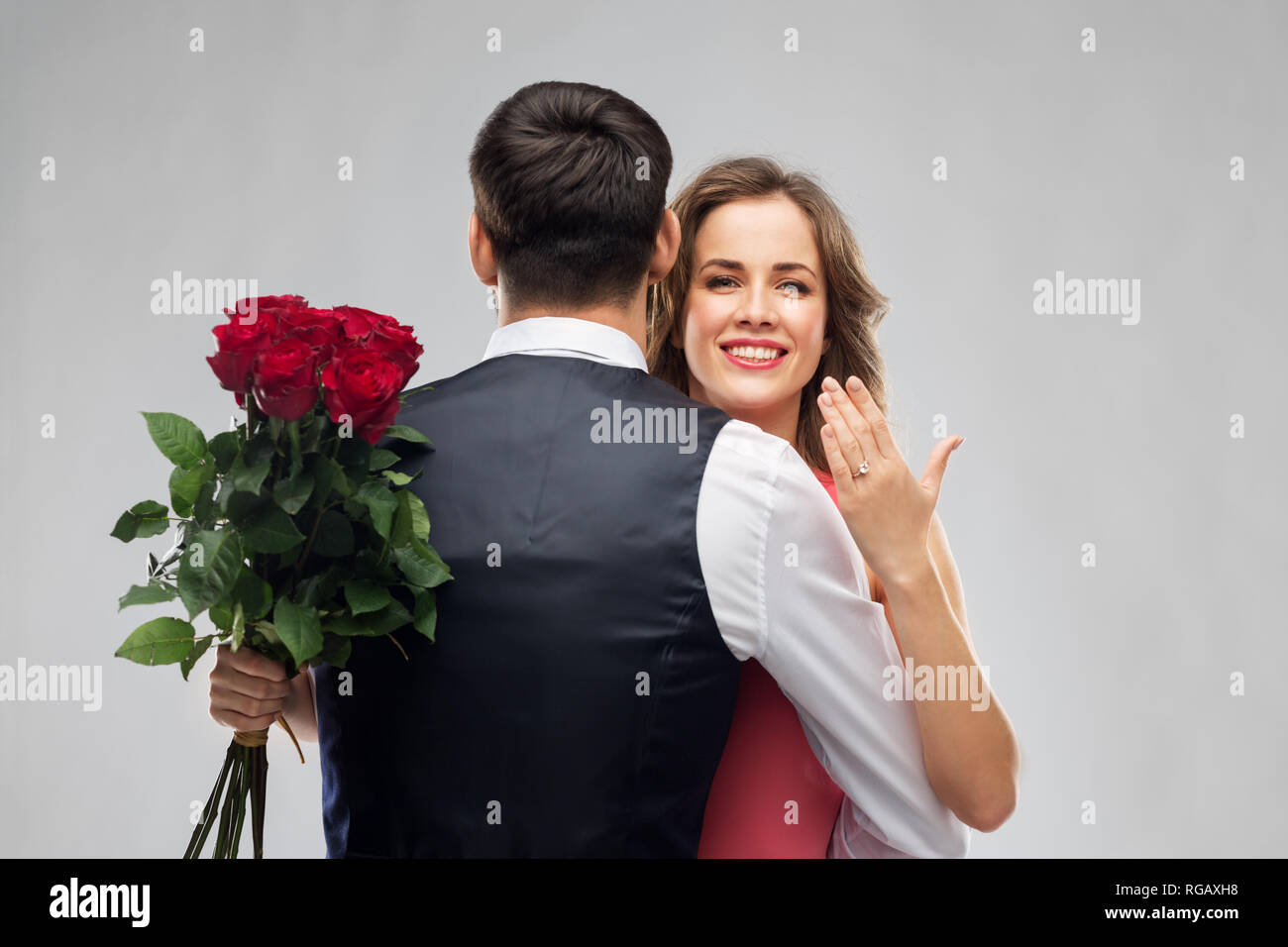 woman with engagement ring and roses hugging man Stock Photo - Alamy