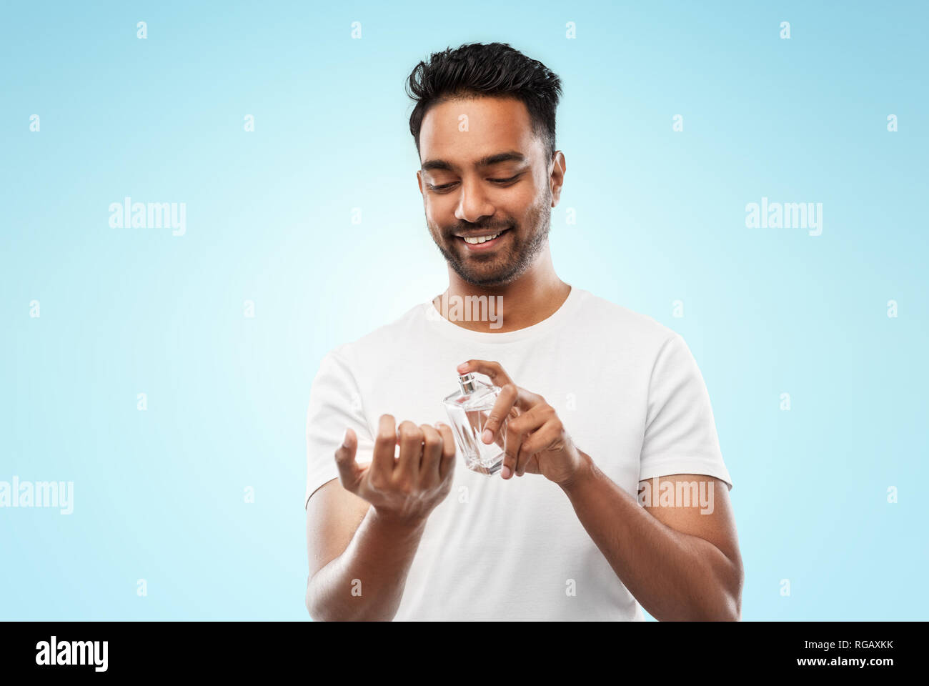 happy indian man with perfume over blue background Stock Photo - Alamy