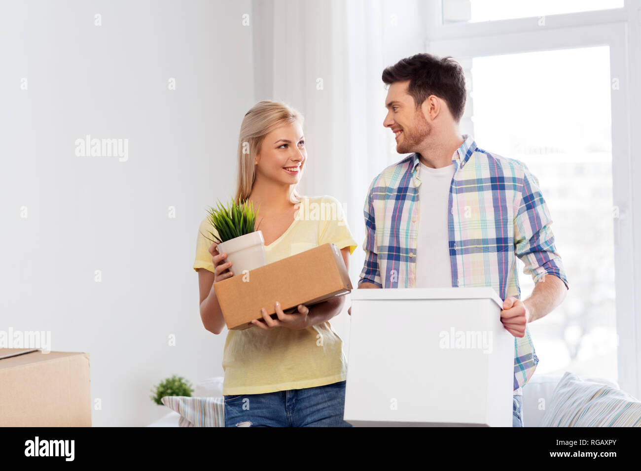 happy couple with boxes moving to new home Stock Photo - Alamy