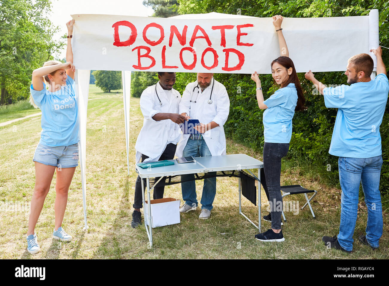 Team Volunteer sets up a booth and advertises a blood donation campaign ...