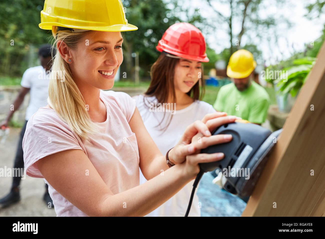 Two women in joiner training are working with a grinder Stock Photo - Alamy