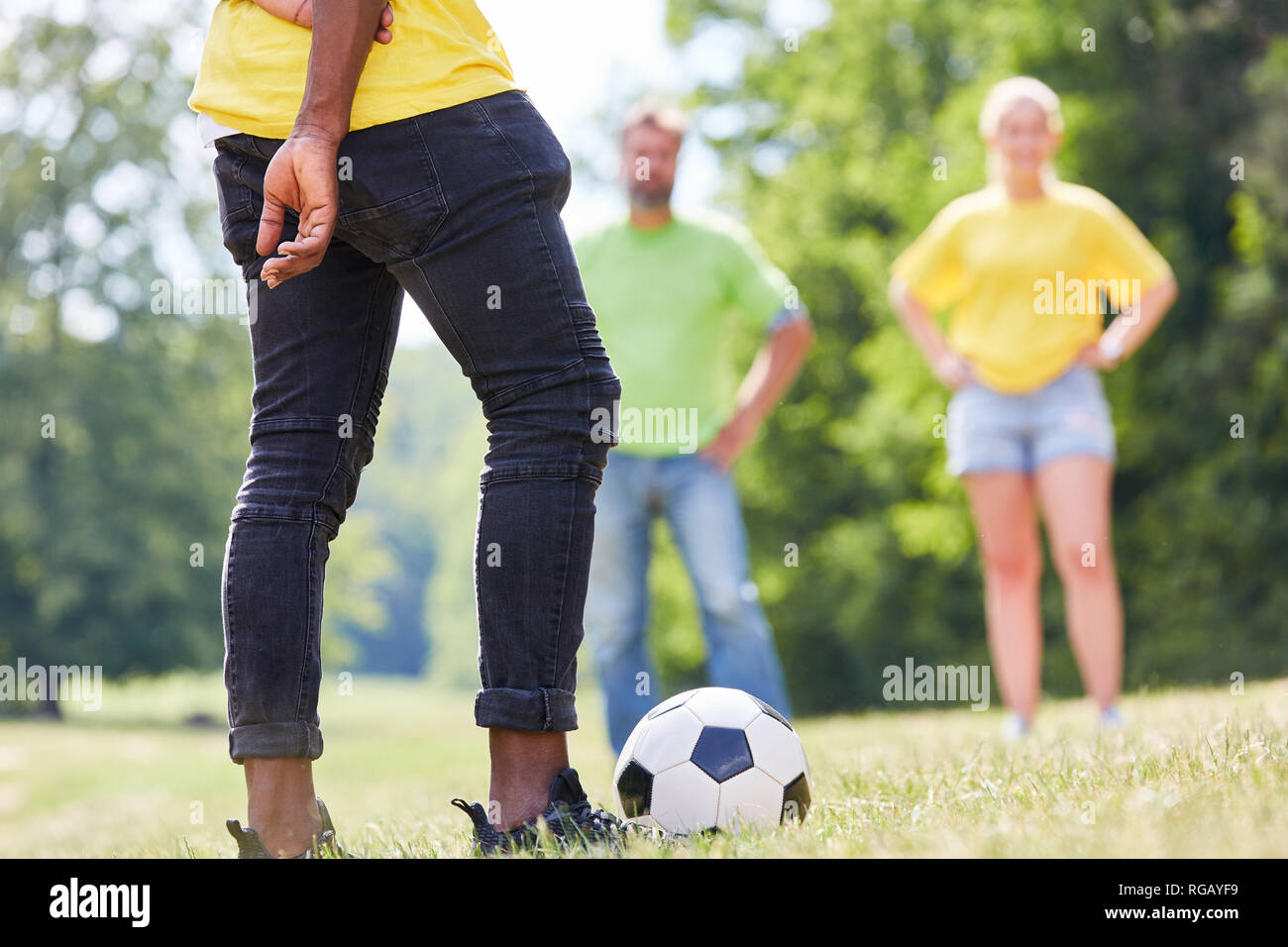 Young people play football on a meadow at a workshop or sports festival ...