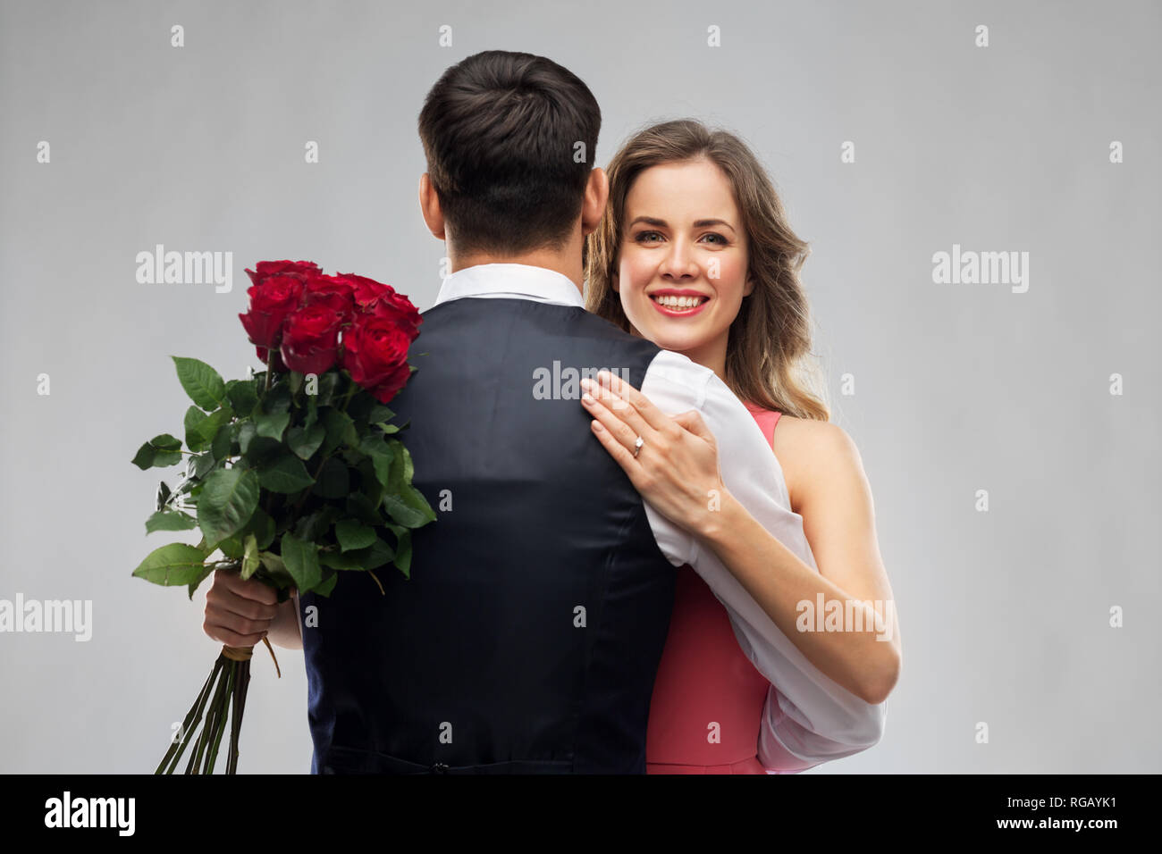 woman with engagement ring and roses hugging man Stock Photo - Alamy