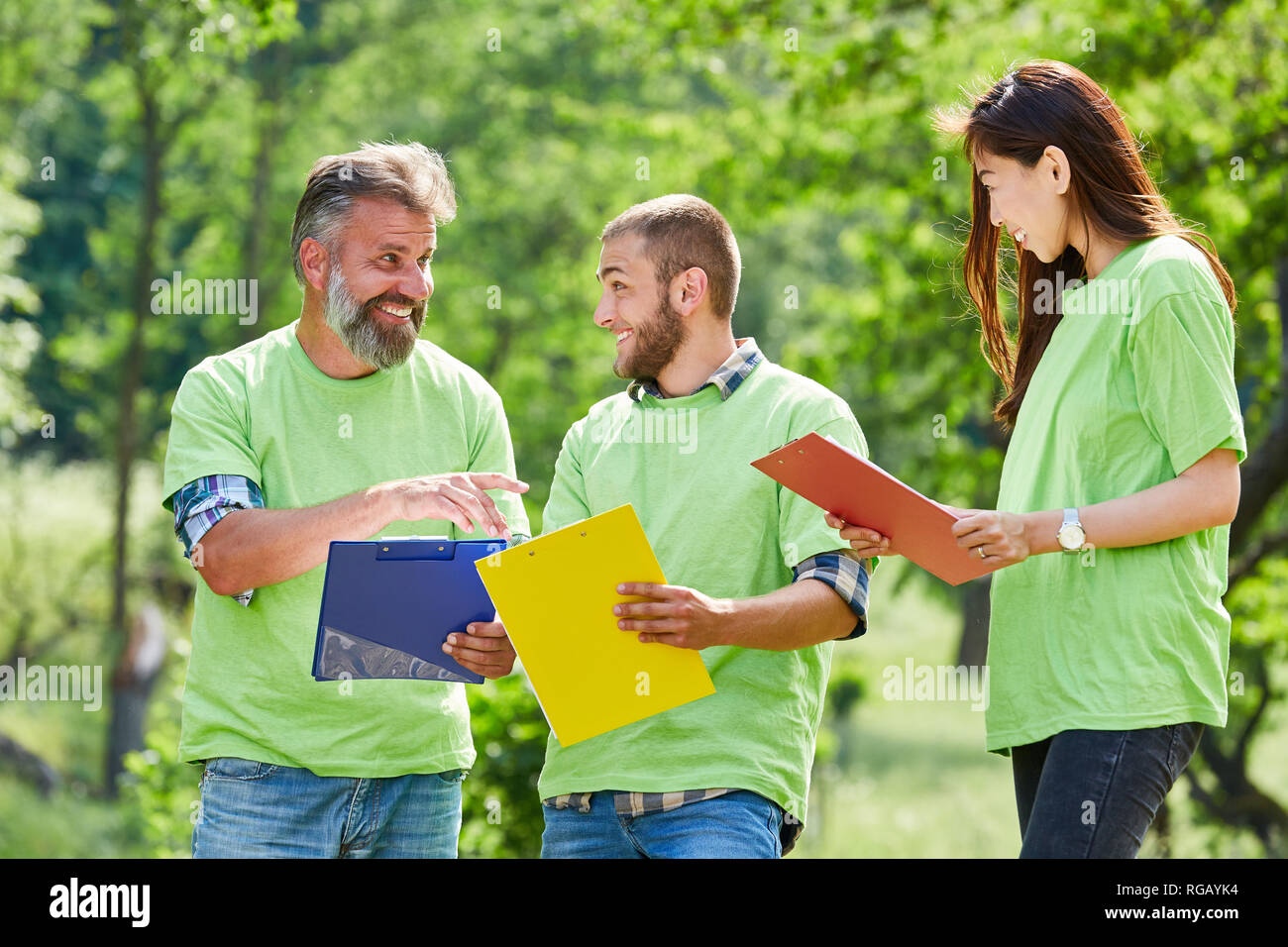 Three conservation activists discuss a conservation project in nature ...
