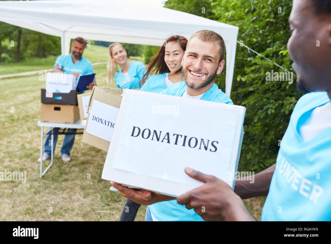 Team volunteer collecting donations with donations box works in ...