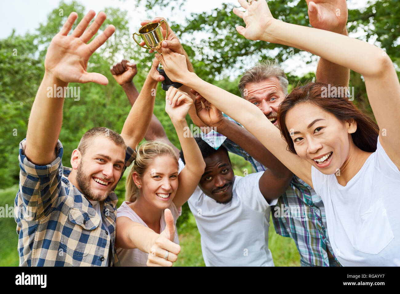 Group of friends as a multicultural team celebrates a victory in a ...