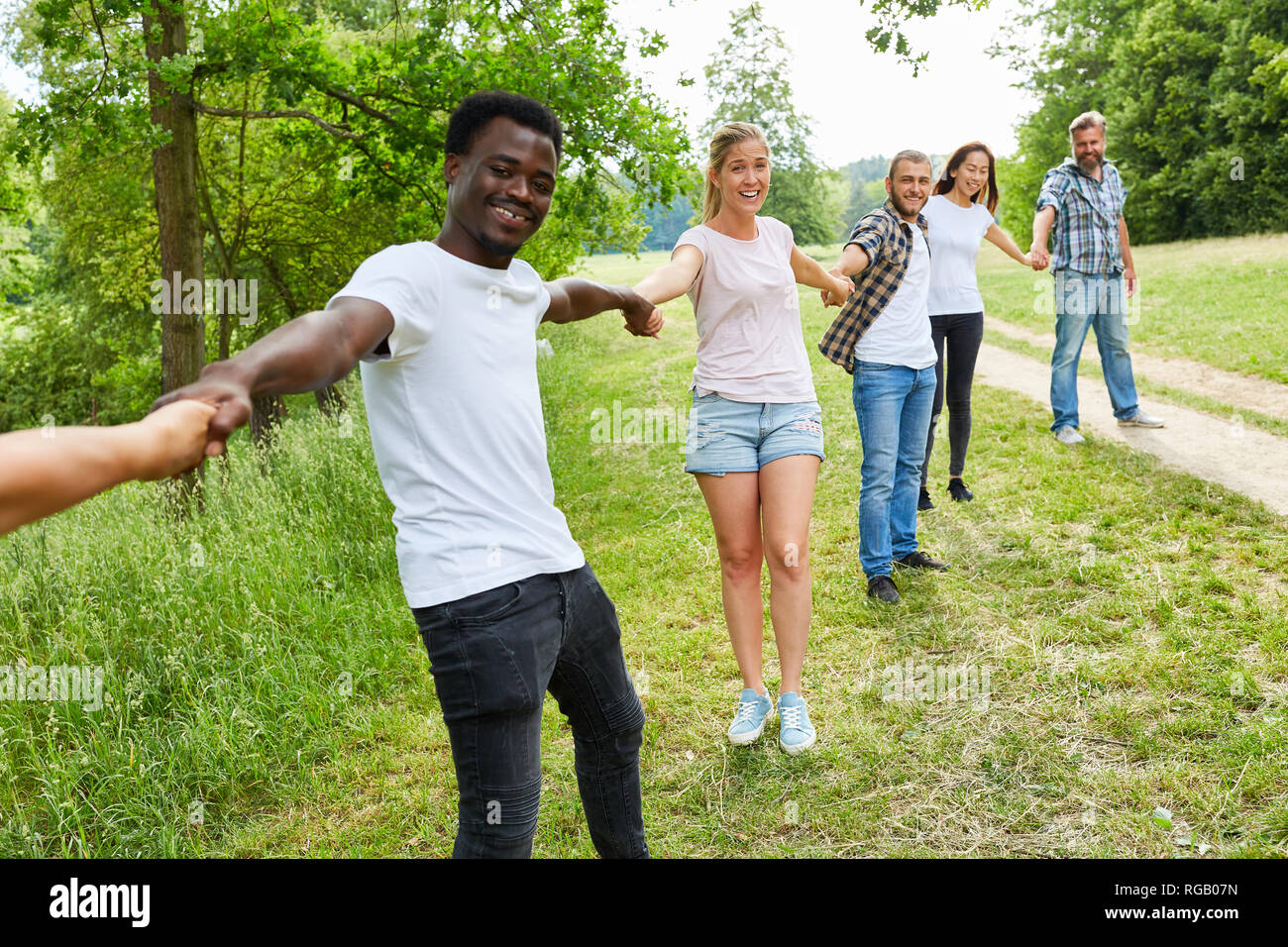 Young people hold hands and form a human chain in the park Stock Photo ...