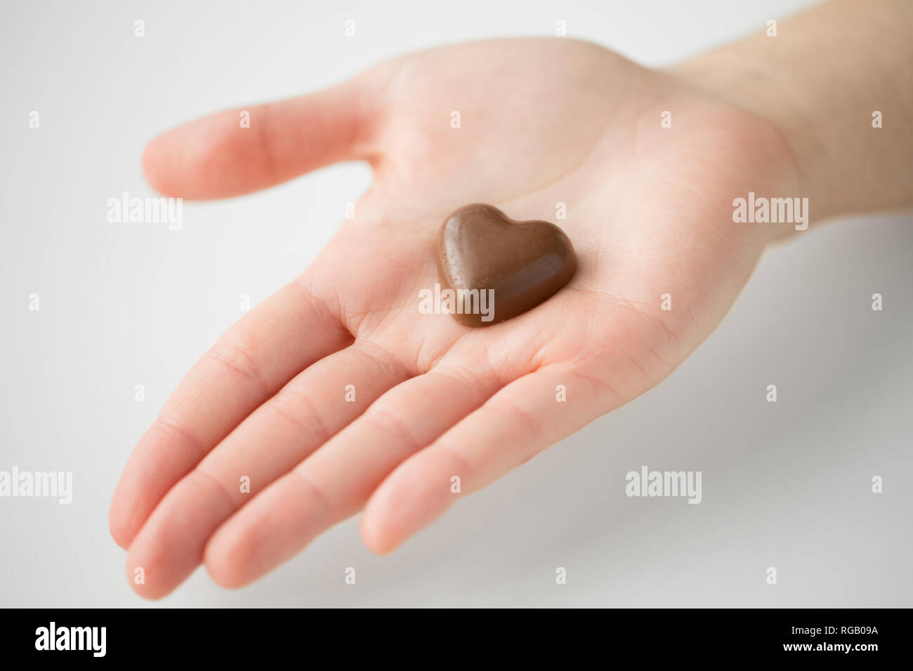 close up of hand with heart shaped chocolate candy Stock Photo - Alamy