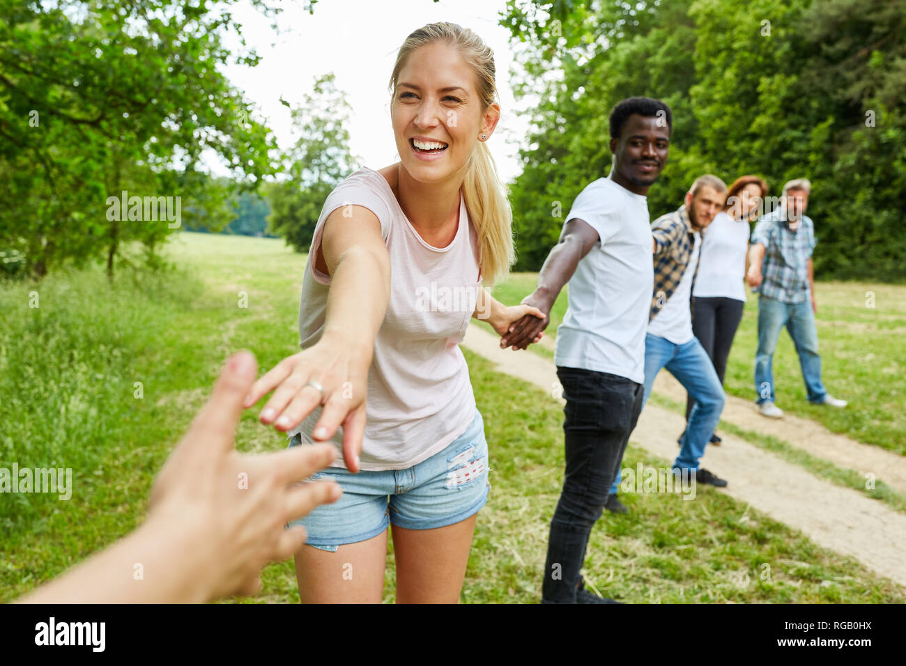 Group of students hold hands as teambuilding exercise in nature Stock ...