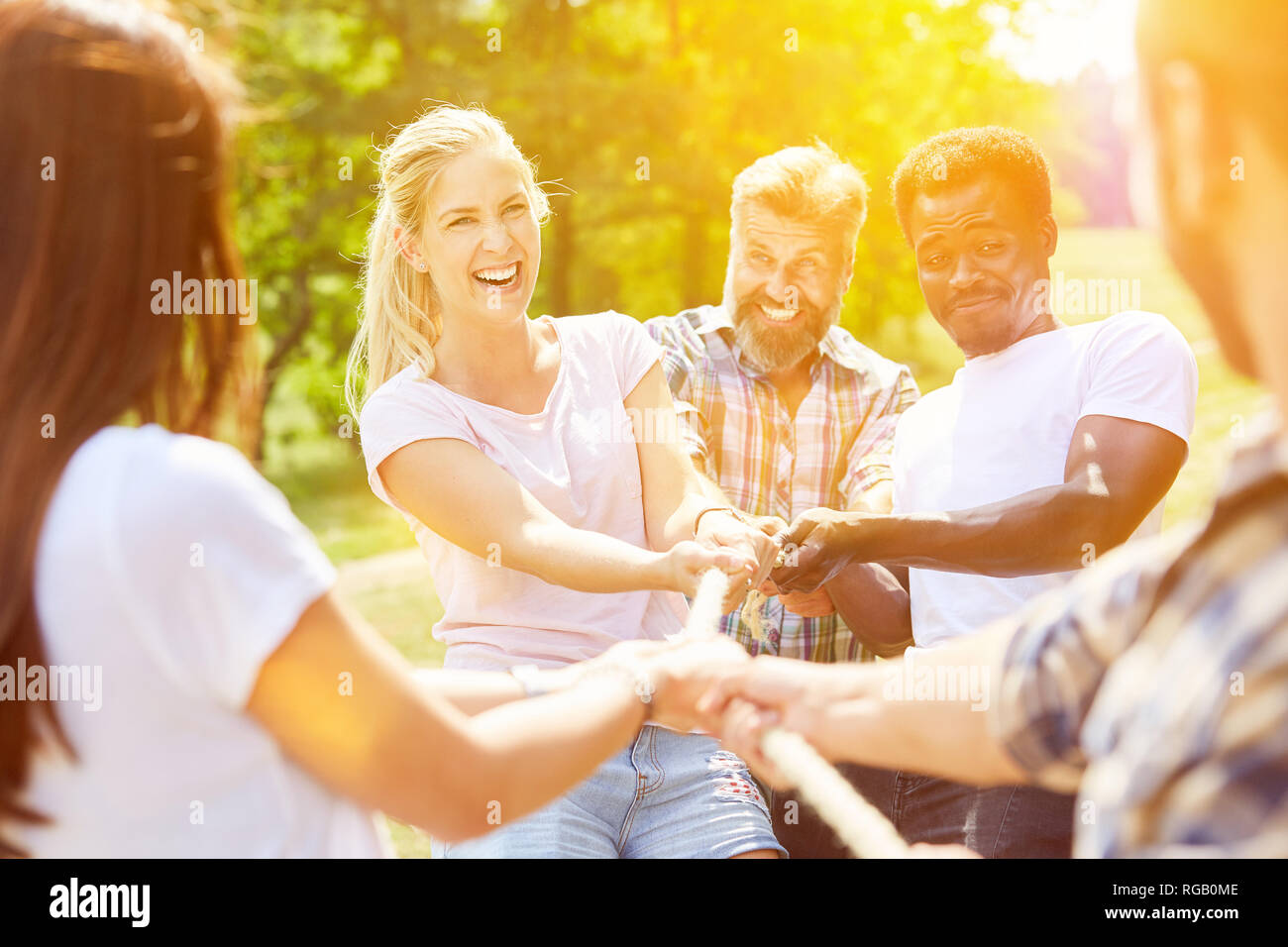 Team together in tug of war as teambuilding event in nature Stock Photo ...