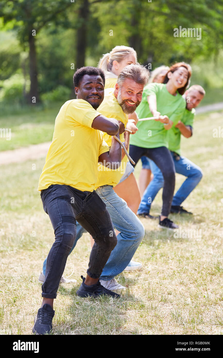 Two happy teams in tug-of-war with rope at a team building event Stock ...