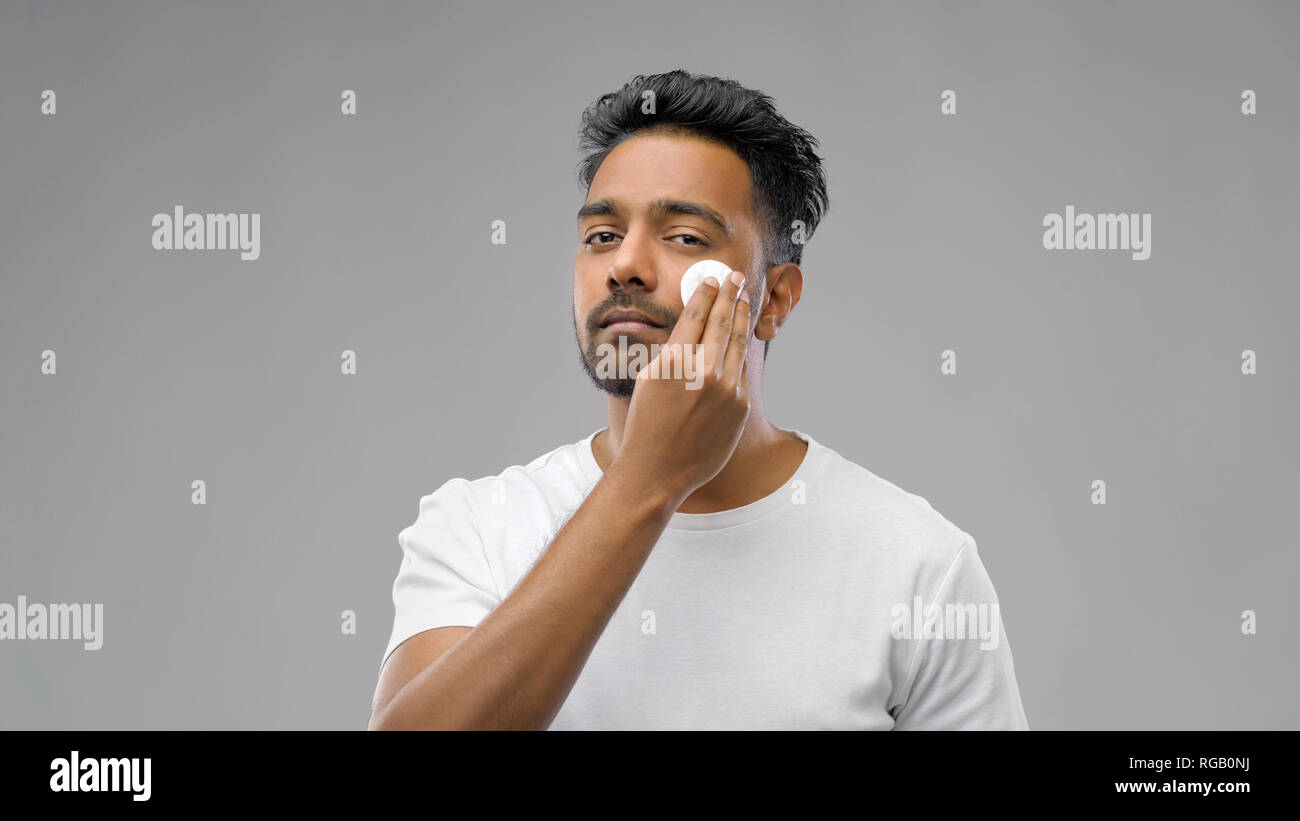 smiling indian man cleaning face with cotton pad Stock Photo - Alamy