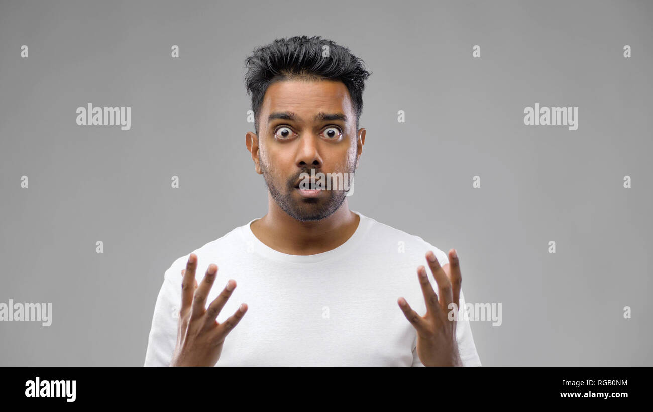 shocked indian man over grey background Stock Photo - Alamy