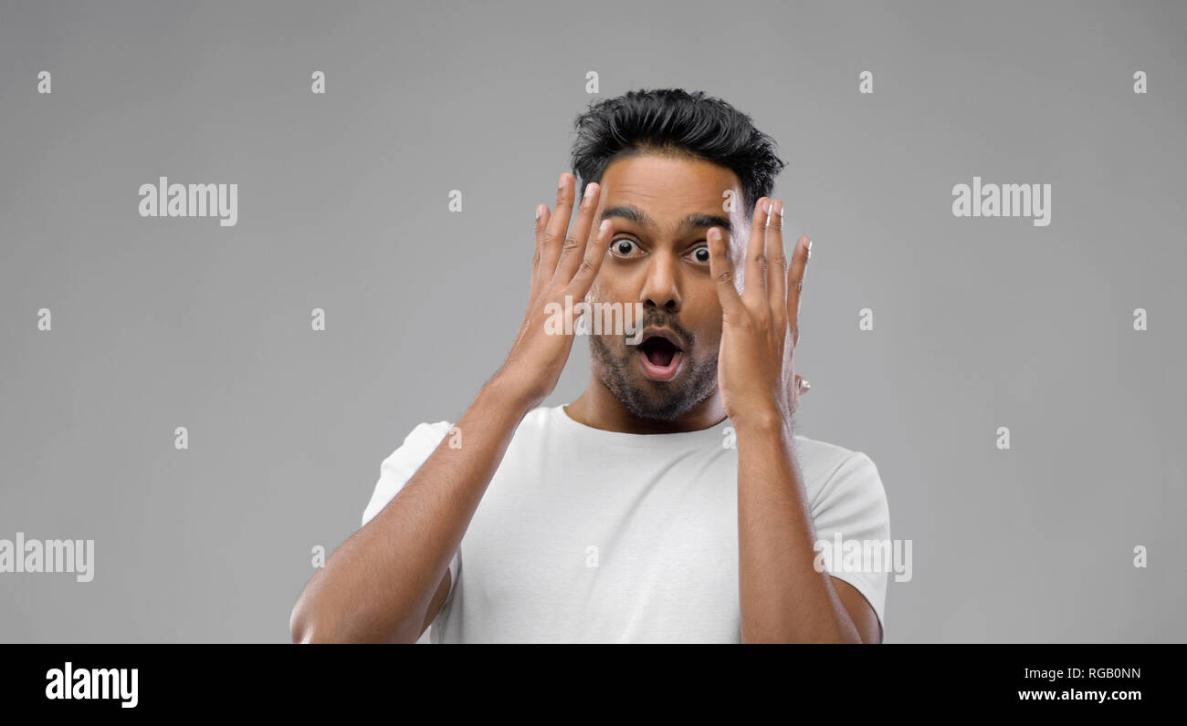 shocked indian man over grey background Stock Photo - Alamy