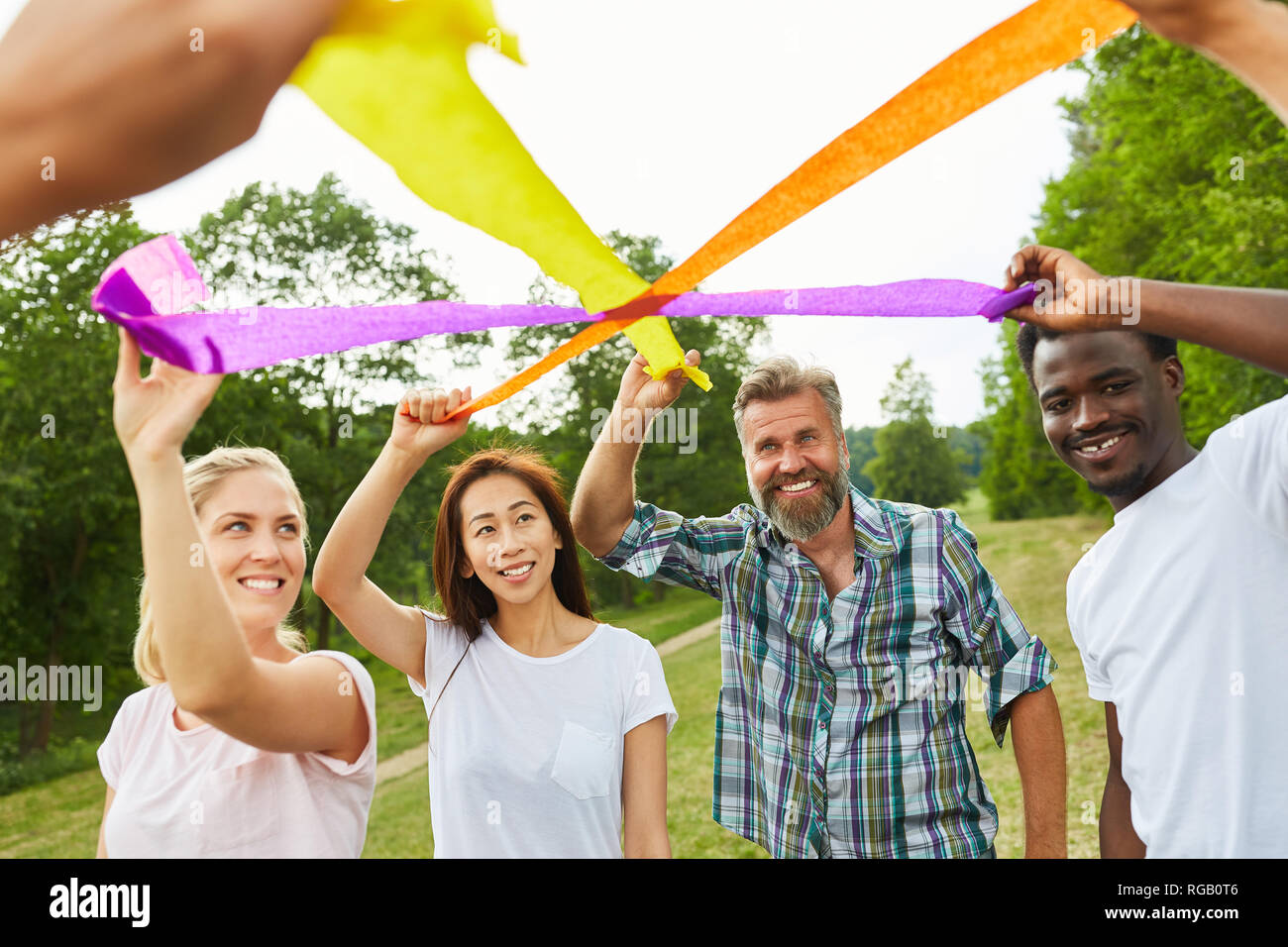 Multicultural team with colorful ribbons exercises teambuilding and ...