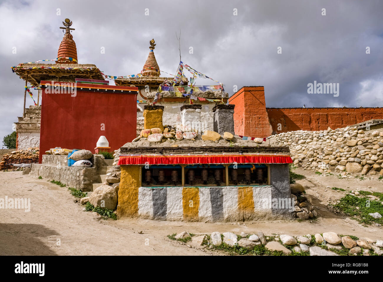 Small shrine with prayer wheels below the city wall of town Stock Photo ...
