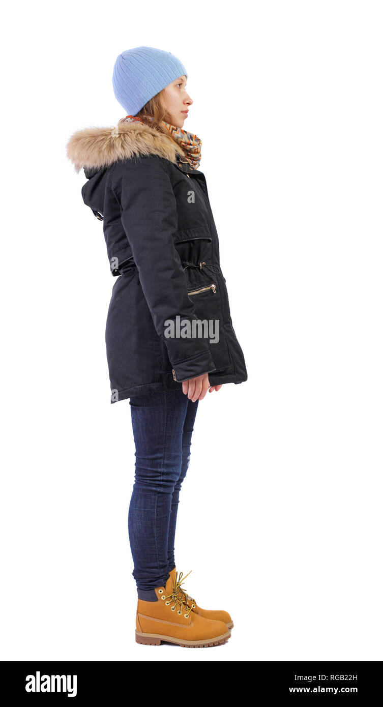 Back view woman in a black winter jacket with fur and blue hat ...