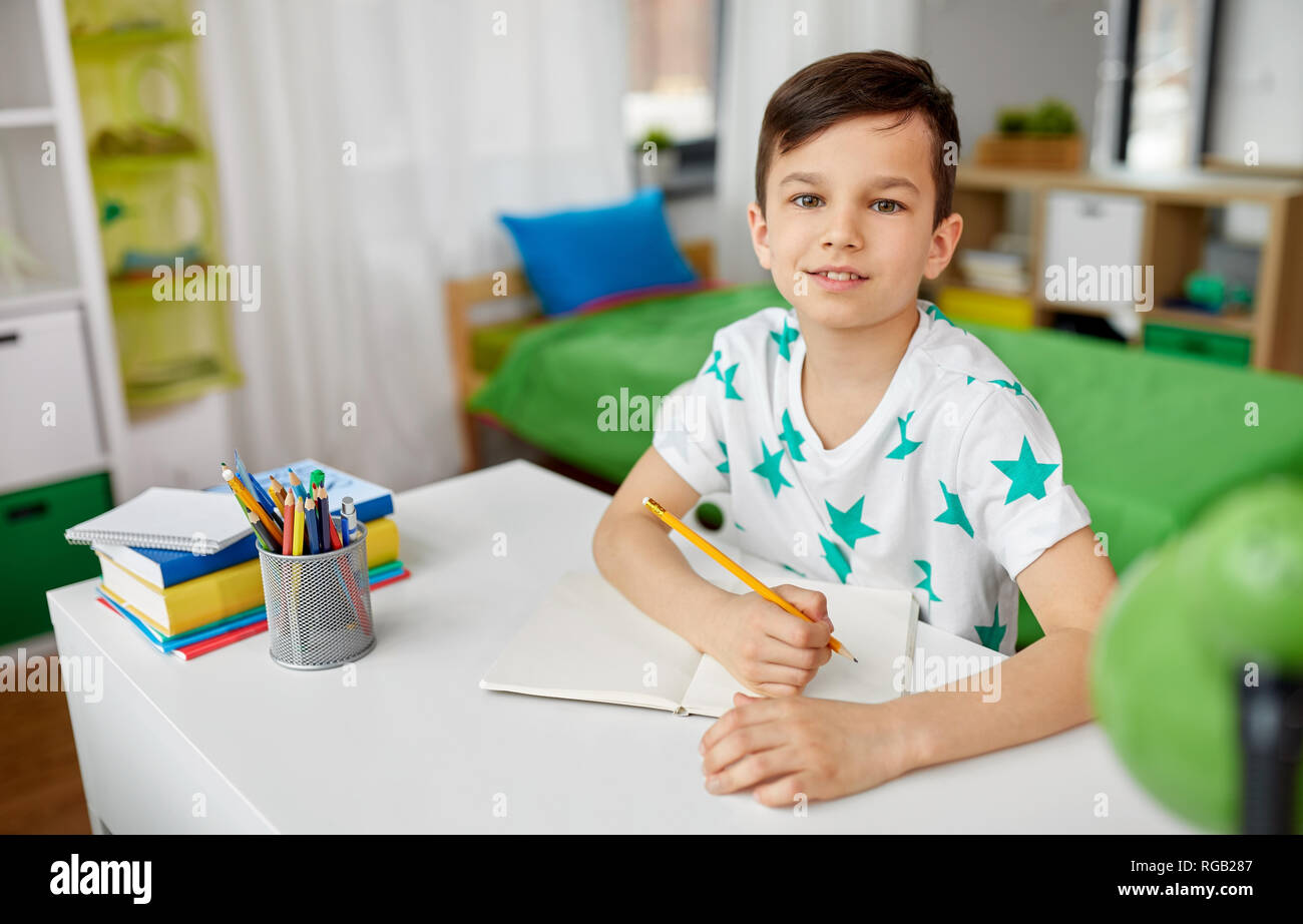 happy boy writing or drawing to notebook at home Stock Photo - Alamy
