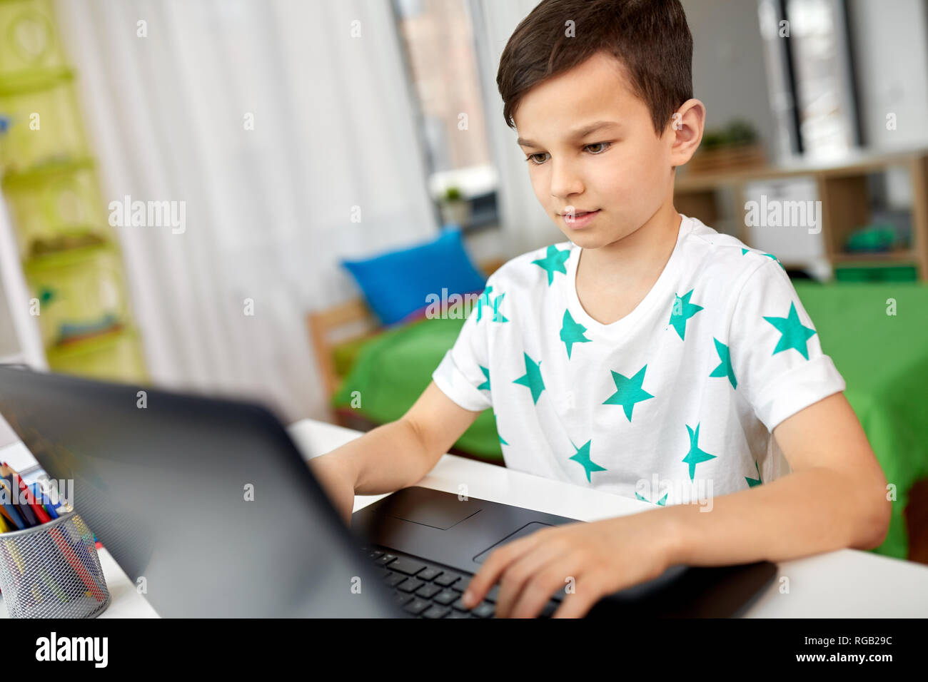 student boy typing on laptop computer at home Stock Photo - Alamy