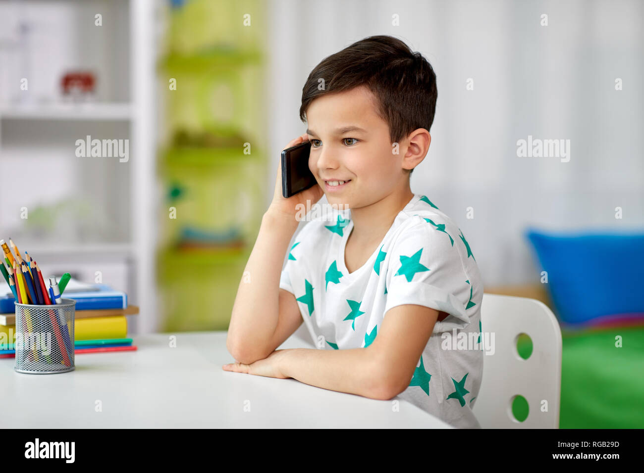 happy boy calling on smartphone at home Stock Photo - Alamy