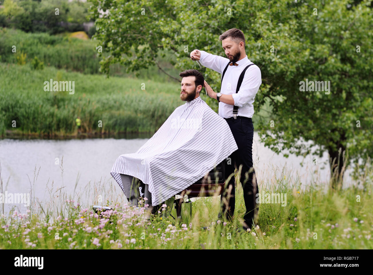 Barber does her hair and shaves the beard of the client in the Barber ...