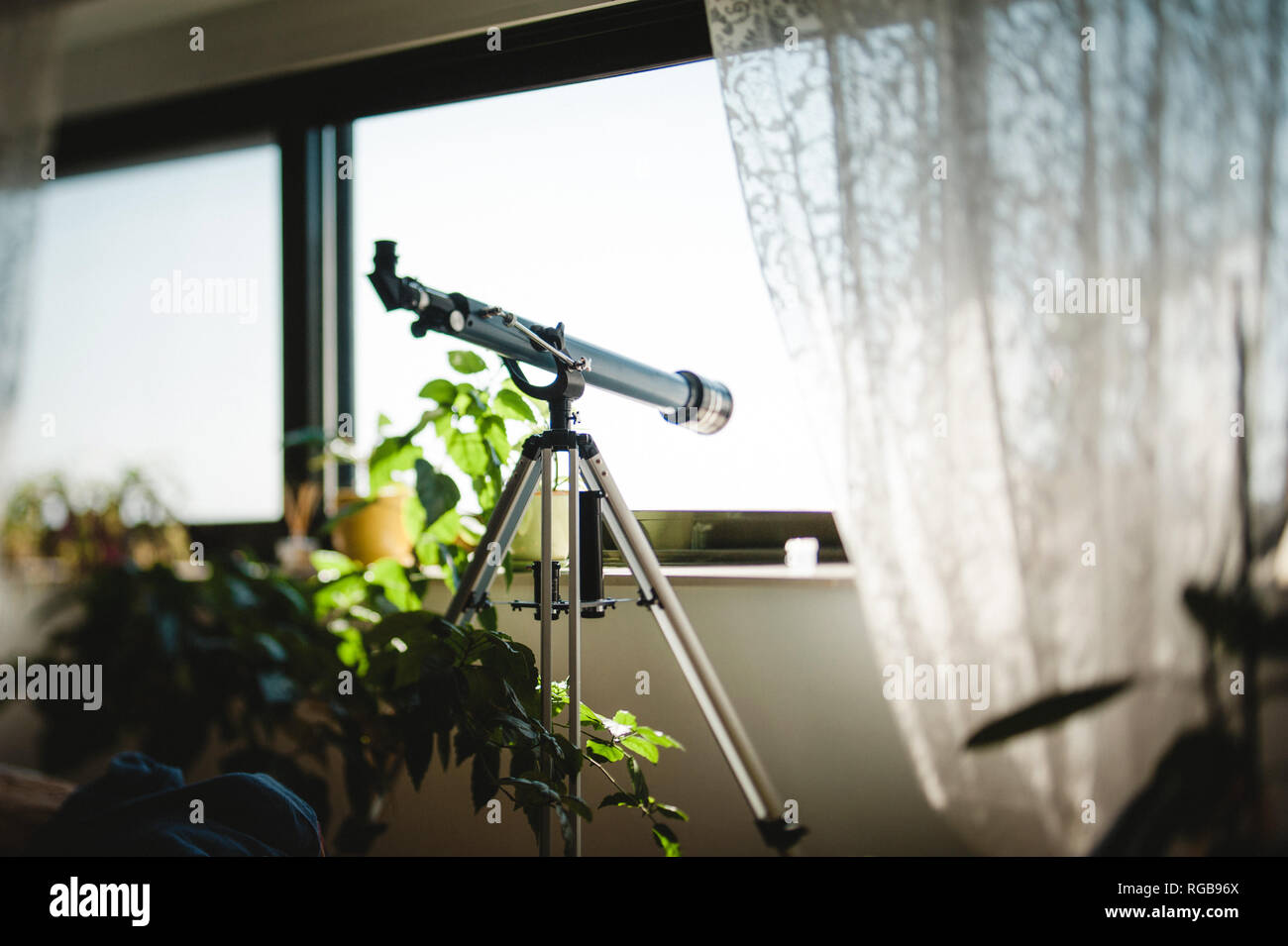 Luxury house interior with wide glass windows and amateur telescope ...