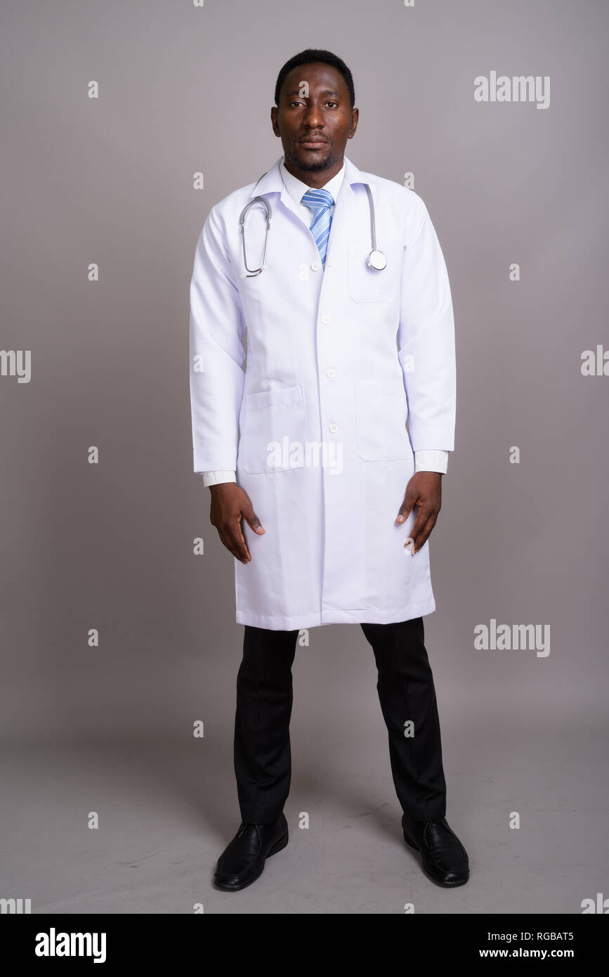 Young handsome African man doctor against gray background Stock Photo ...