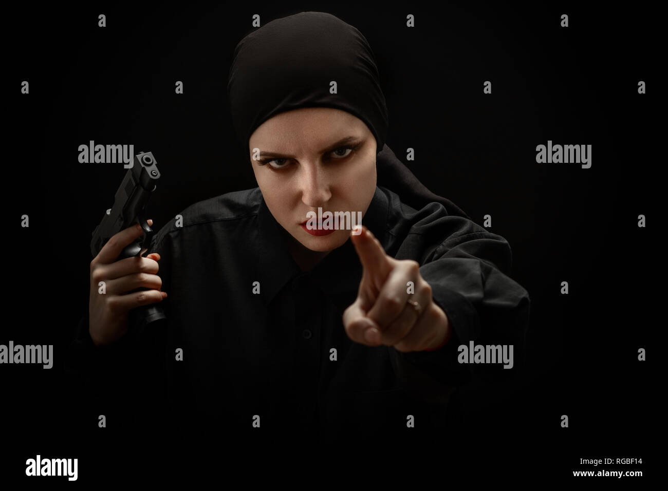serious girl with gun aiming at camera on black background Stock Photo ...