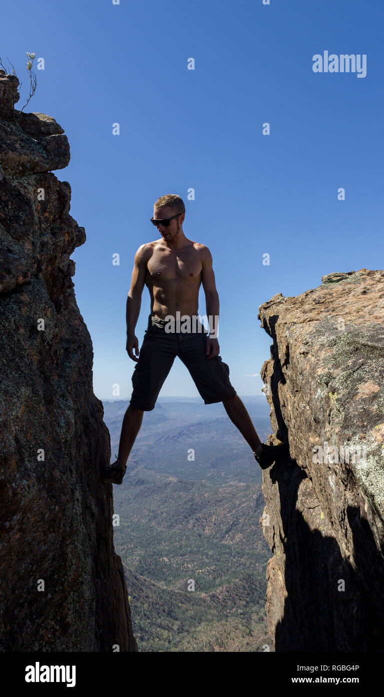 jung man standing between 2 rocks on St Mary's Peak from the Flinders ...