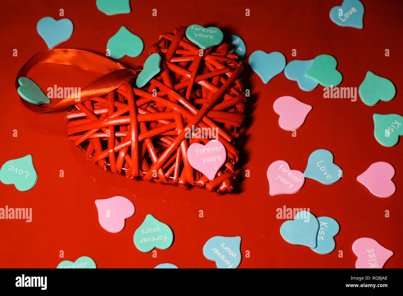 Beautiful red heart closeup with decorations from multi-colored hearts ...