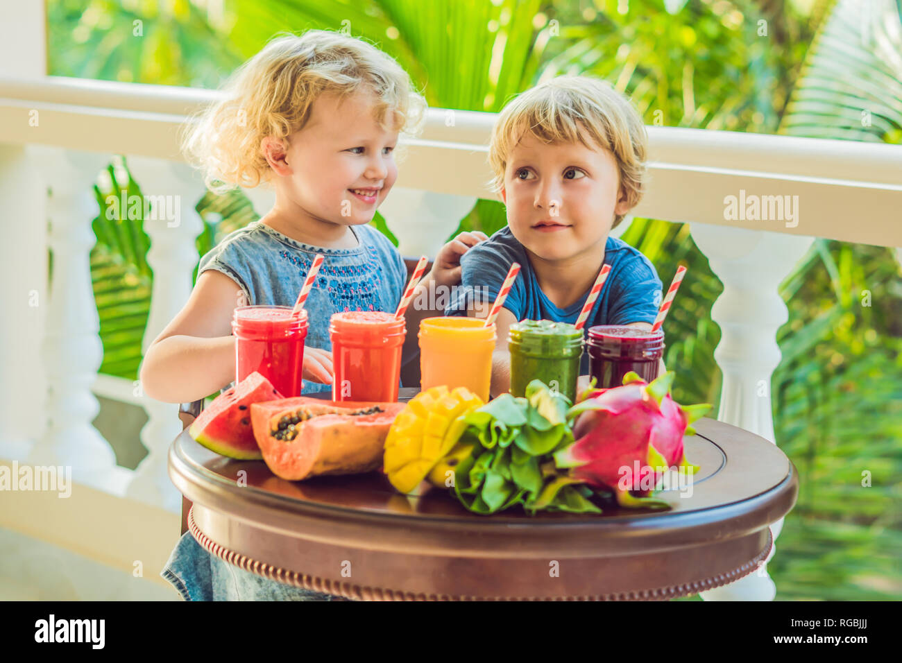 Children drink colorful healthy smoothies.. Watermelon, papaya, mango ...