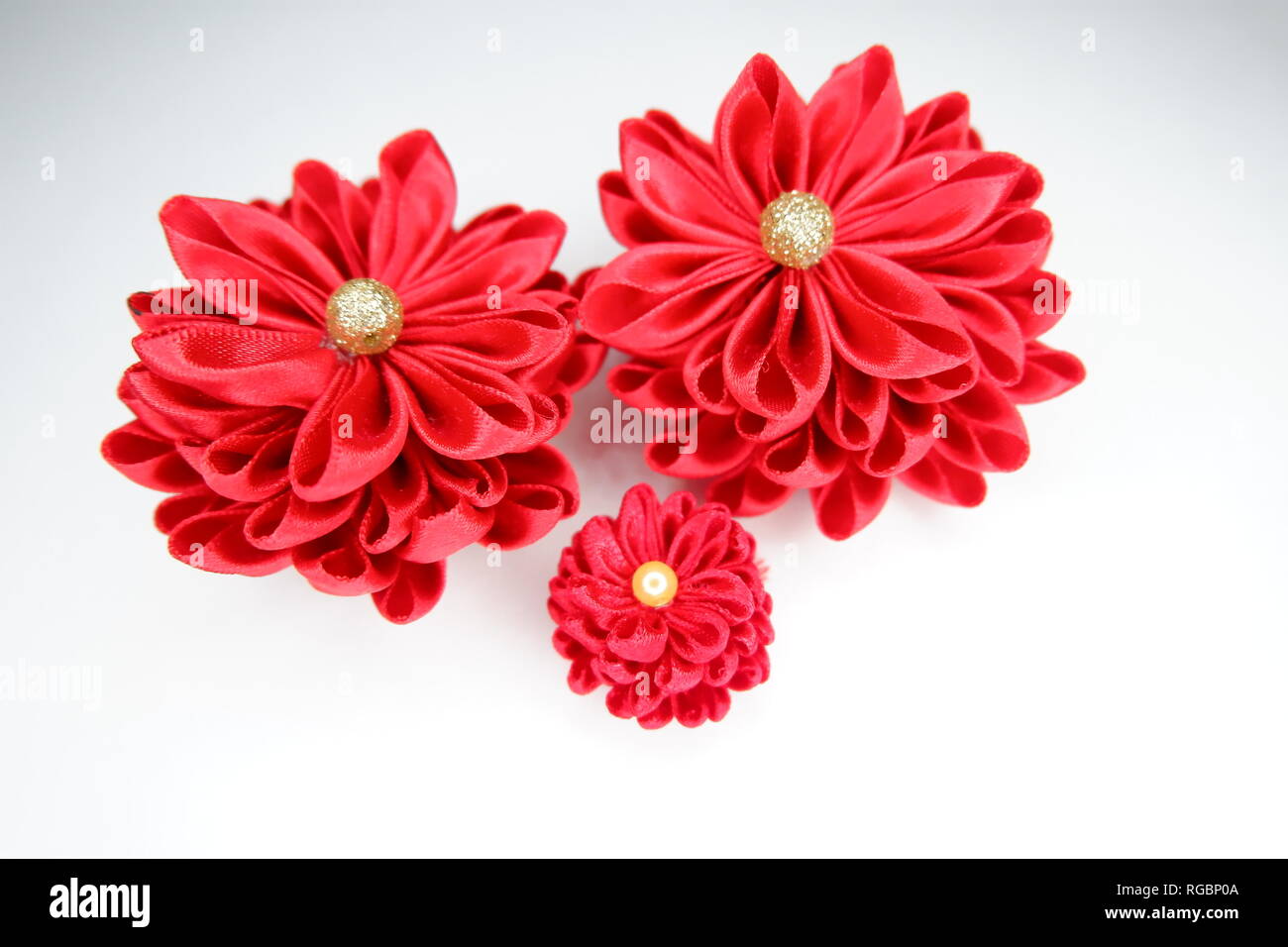 Three handmade red ribbon flowers Stock Photo - Alamy