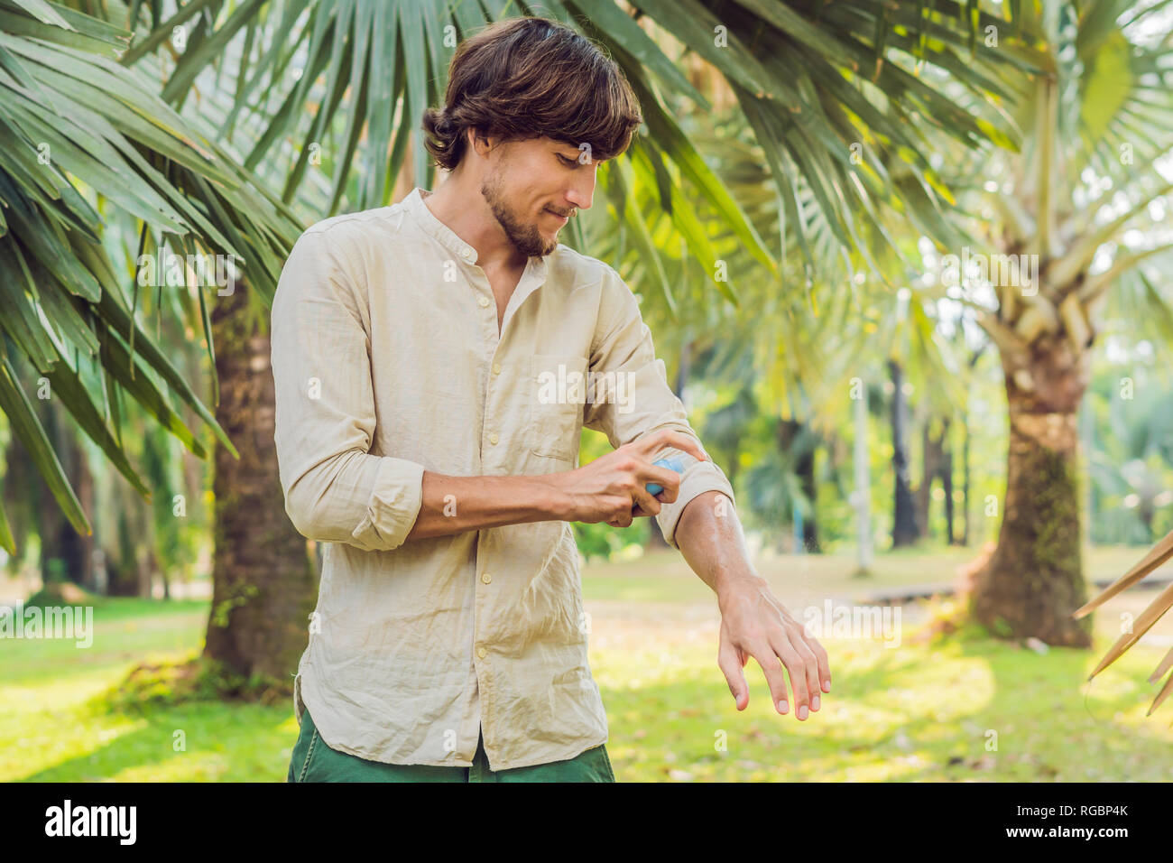 Young man spraying mosquito insect repellent in the forrest, insect ...