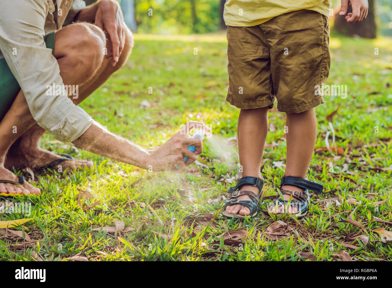 dad and son use mosquito spray.Spraying insect repellent on skin ...