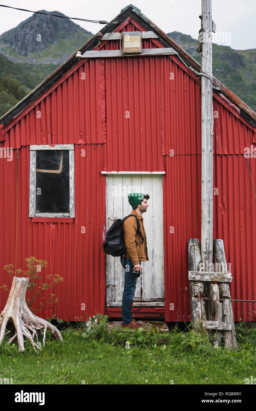 Young man standing in front of corrugated iron shack Stock Photo - Alamy