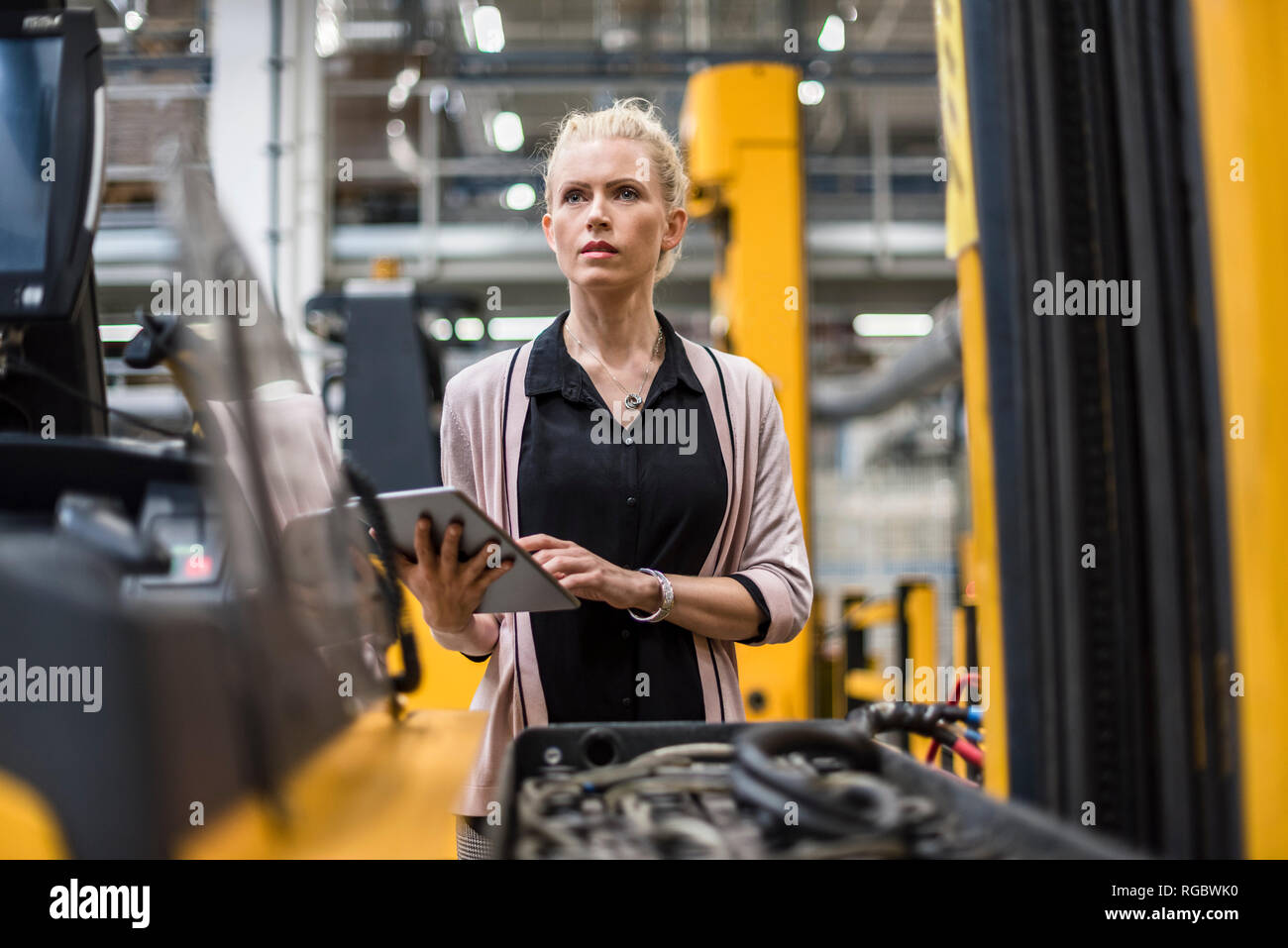 Woman holding tablet in factory shop floor Stock Photo - Alamy