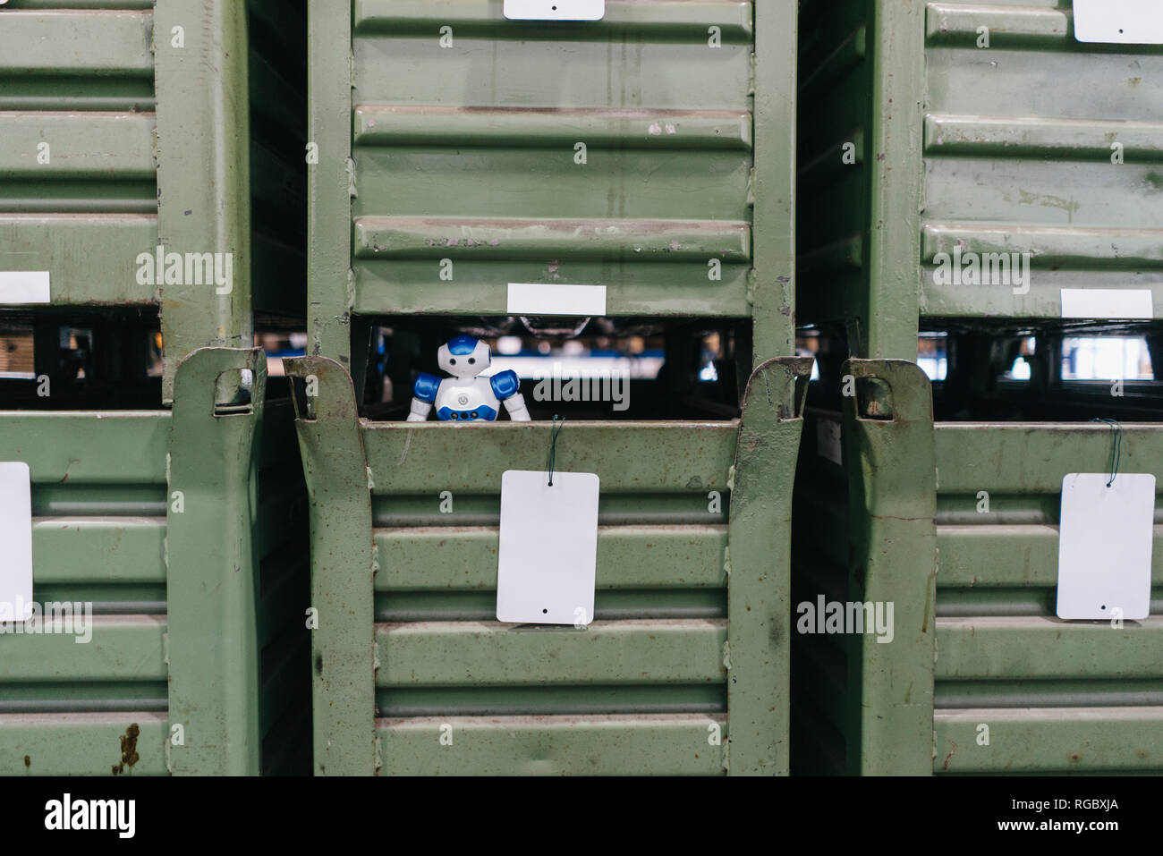 Toy robot looking out of locker in factory storage Stock Photo - Alamy