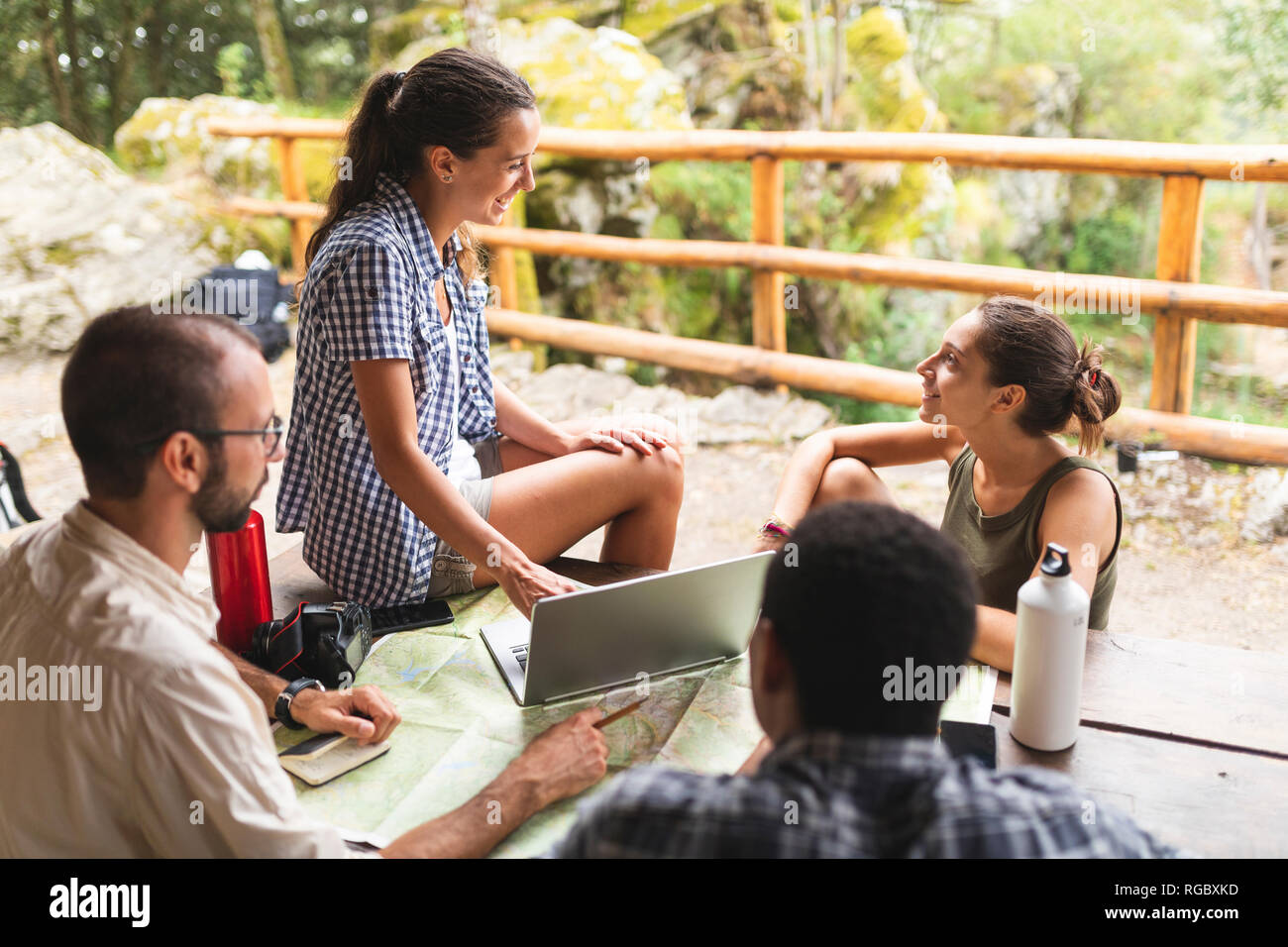 Group of hikers sitting together planning a hiking route using map and ...