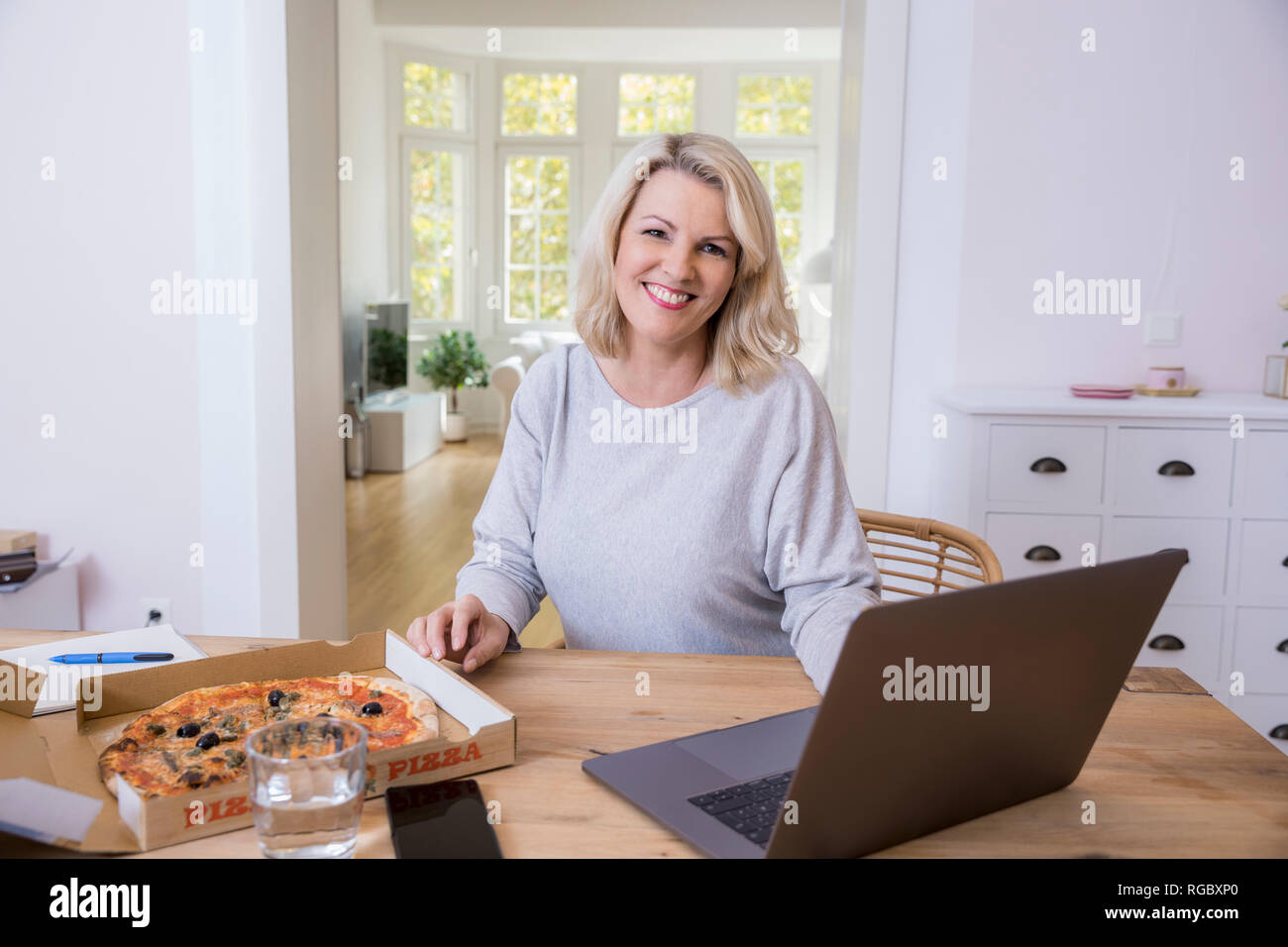 Portrait smiling blond mature woman home office having pizza hi-res ... Portrait smiling blond mature woman home office having pizza hi-res ...