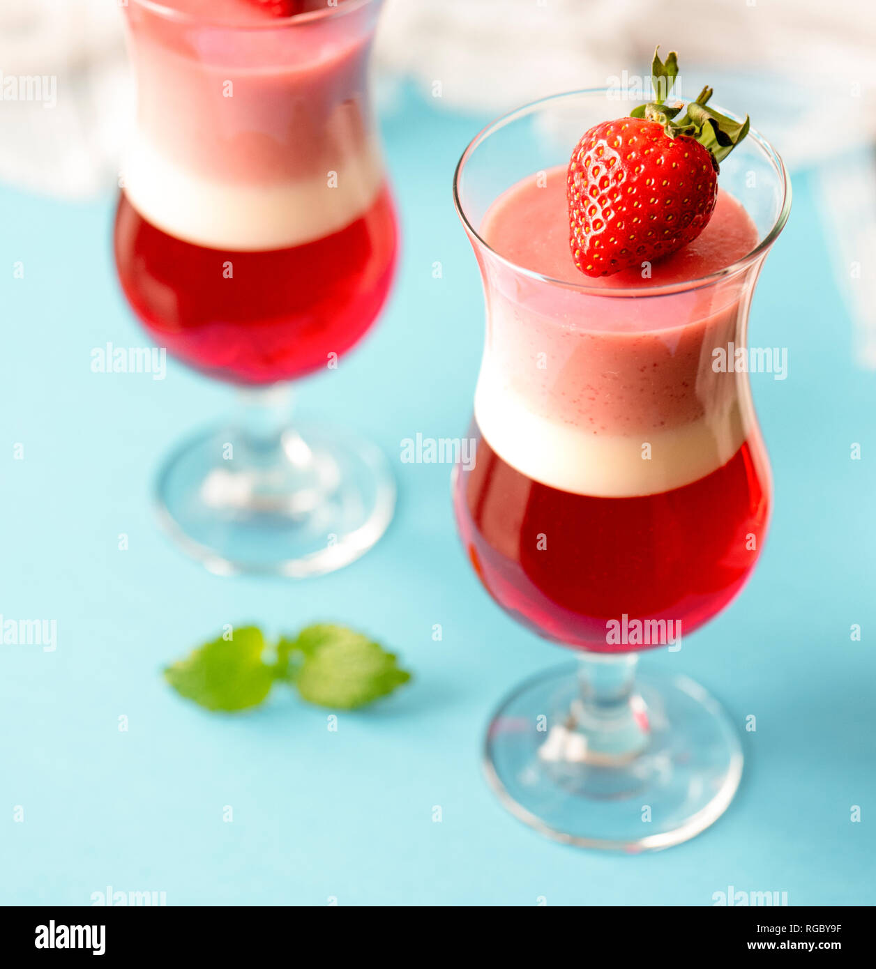Italian cold dessert Panna Cotta with strawberries on blue background ...