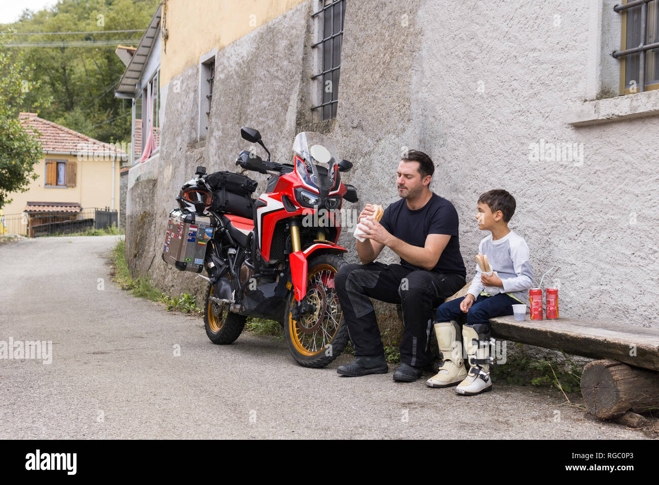 Father and son having a lunch break during a motorbike trip Stock Photo ...
