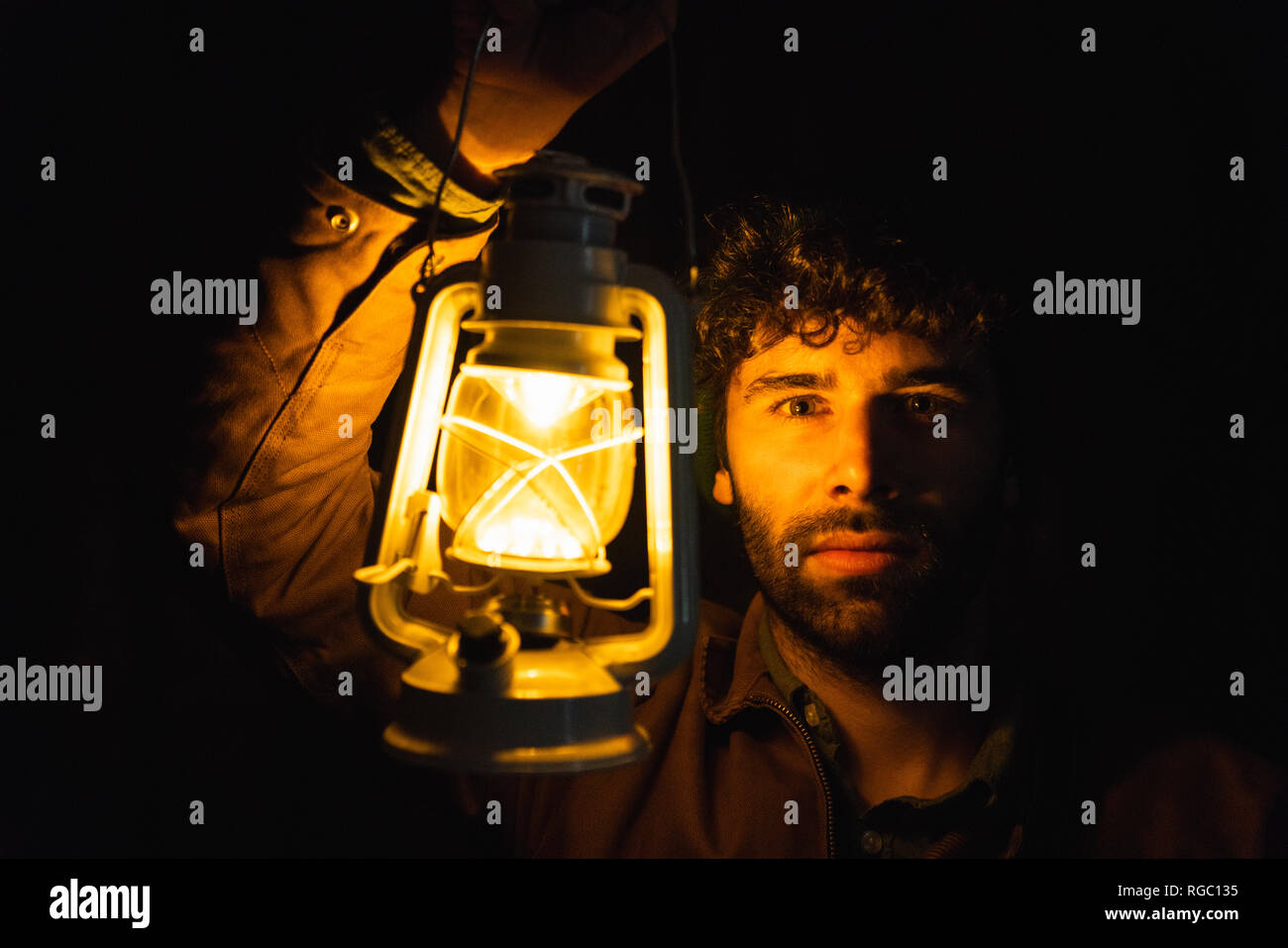 Portrait of man holding storm lantern in the dark Stock Photo - Alamy