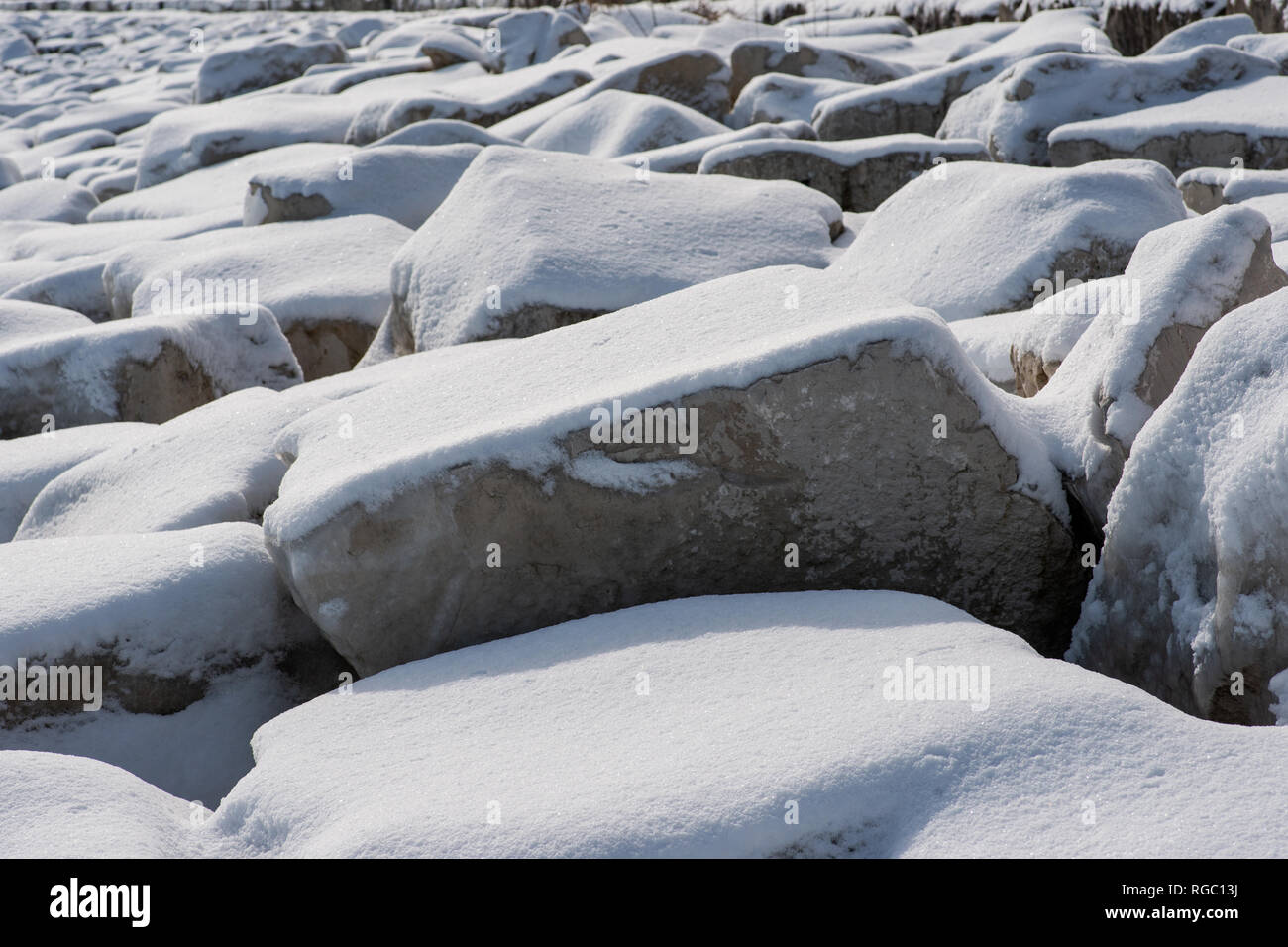 Long line of rocks along Lake Michigan shoreline covered with frozen ...