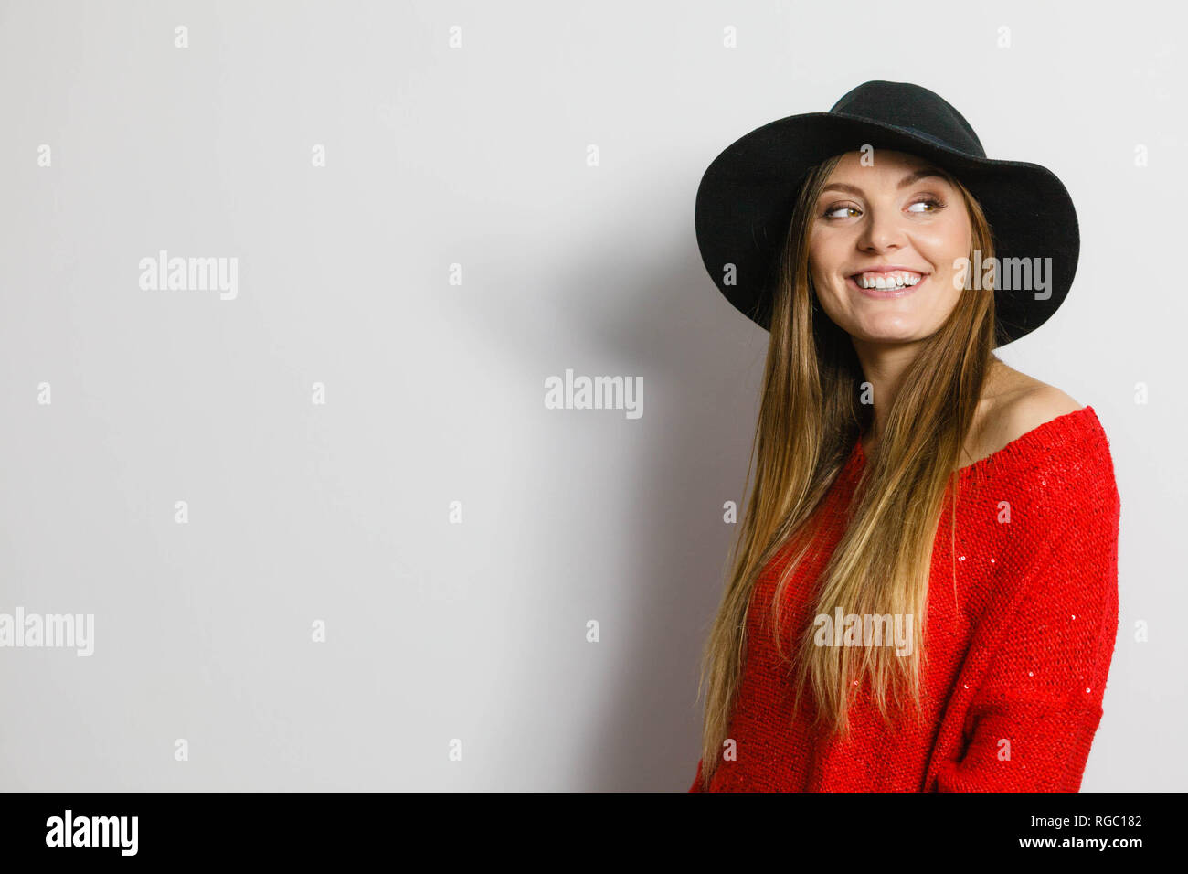 Female autumnal fashion. Woman wearing red sweater black stylish hat ...