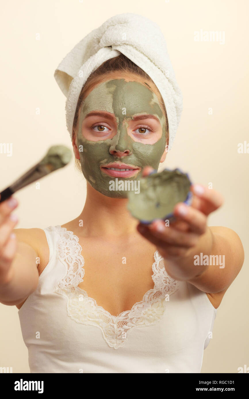 Skin care. Woman applying with brush clay mud mask to her face. Girl ...