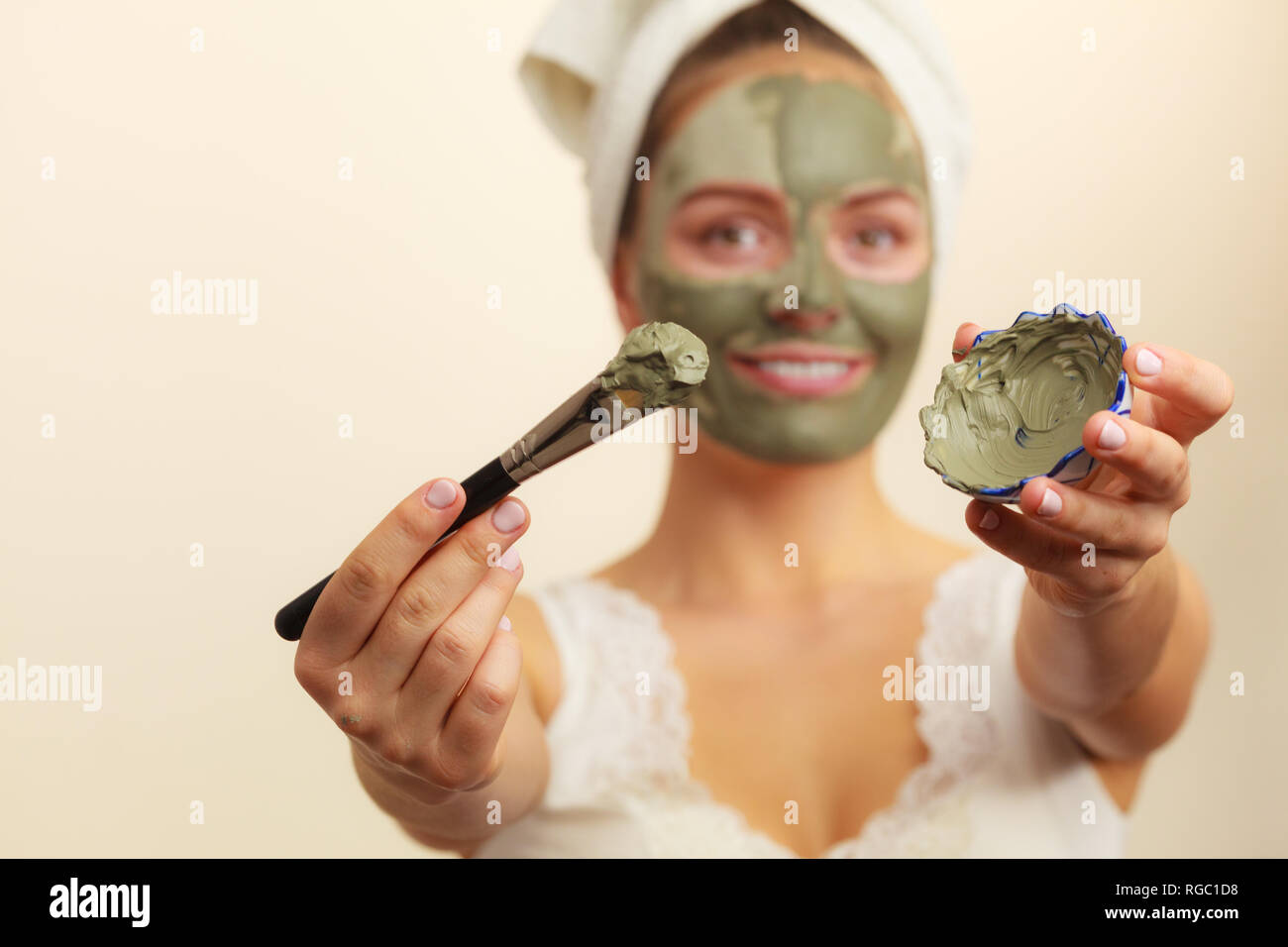 Skin care. Woman applying with brush clay mud mask to her face. Girl ...