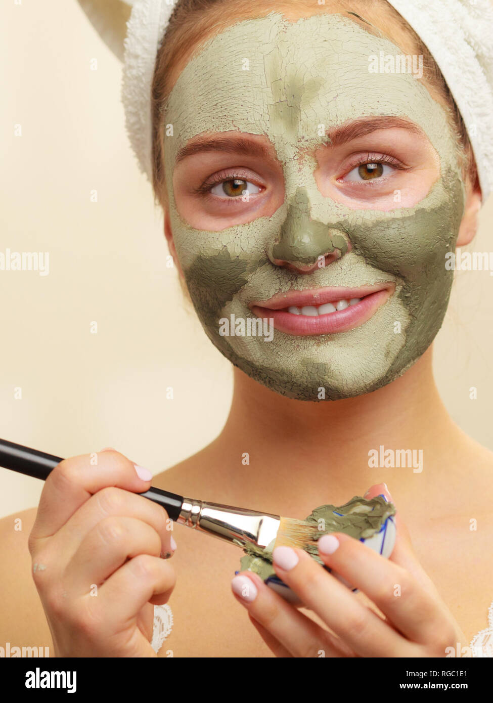 Skin care. Woman applying with brush clay mud mask to her face. Girl ...