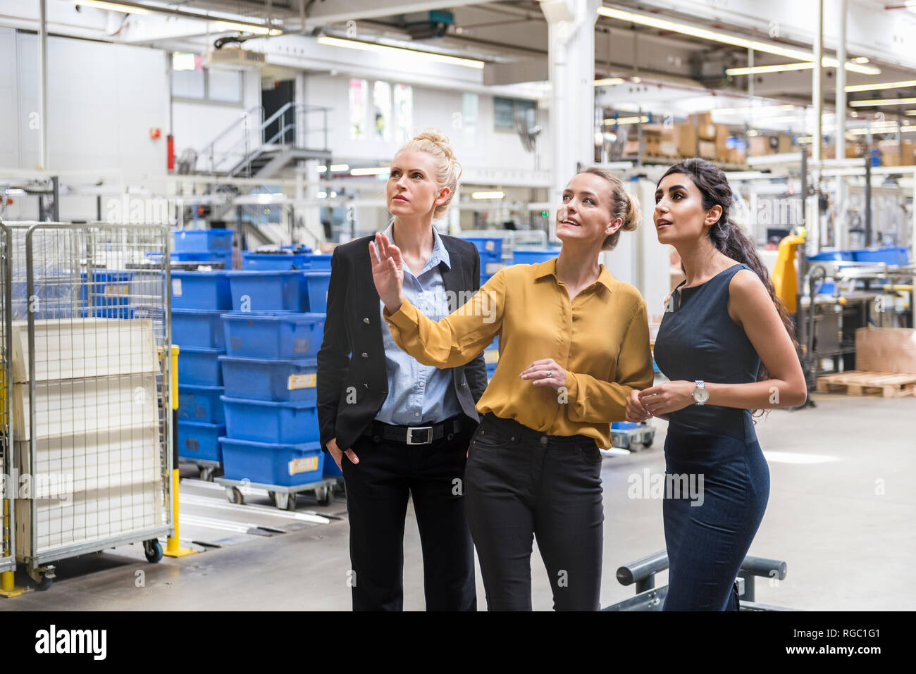 Three women talking in modern factory Stock Photo - Alamy