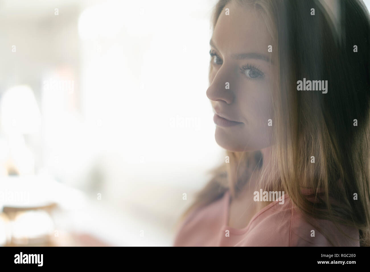Portrait of daydreaming young woman behind glass pane Stock Photo - Alamy