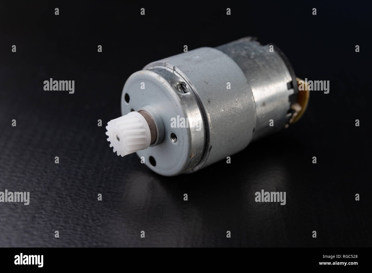 Small electric engine on a wooden dark table. Electric drive for small ...